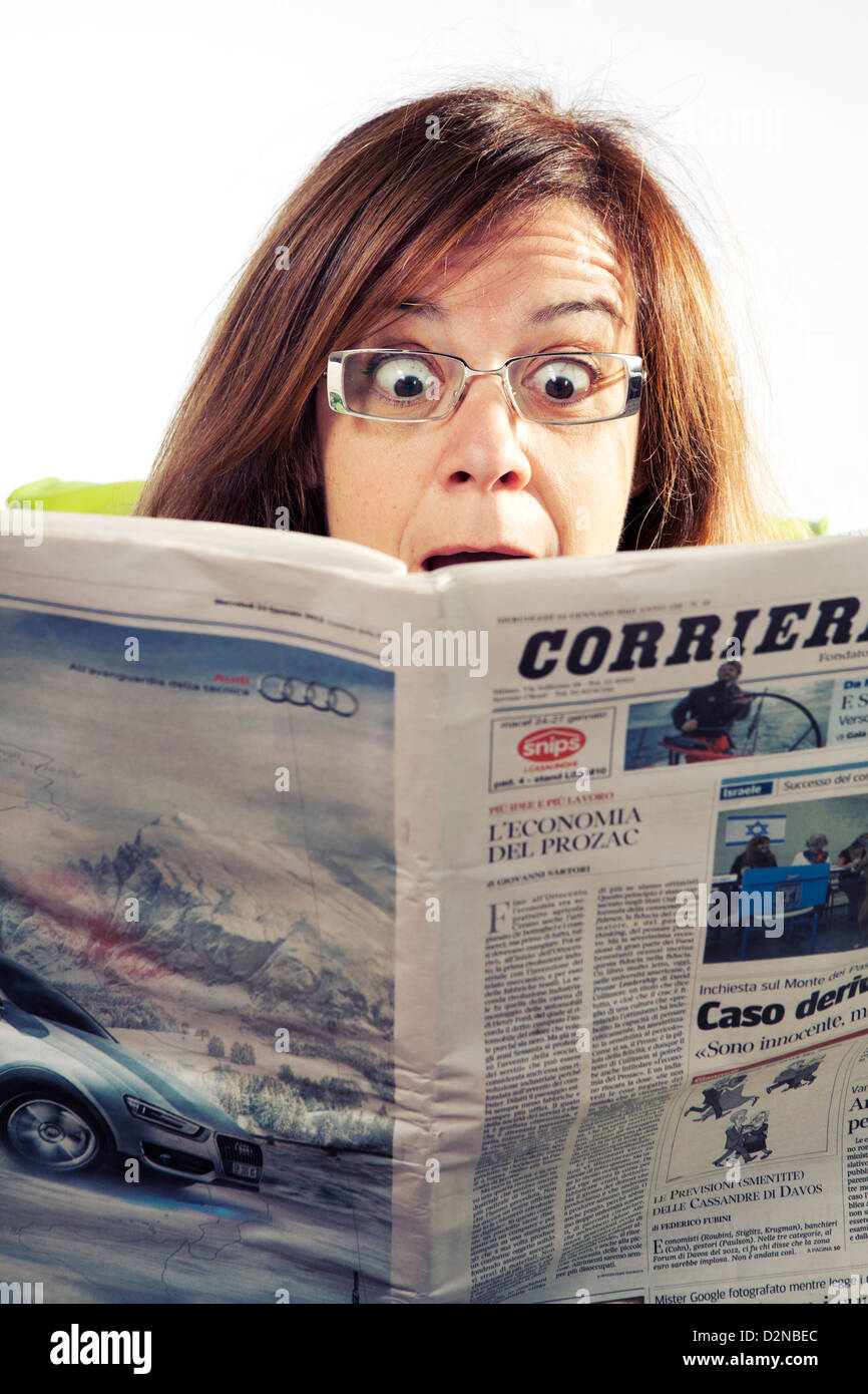 Middle aged woman reading surprising news in the newspaper Stock Photo ...