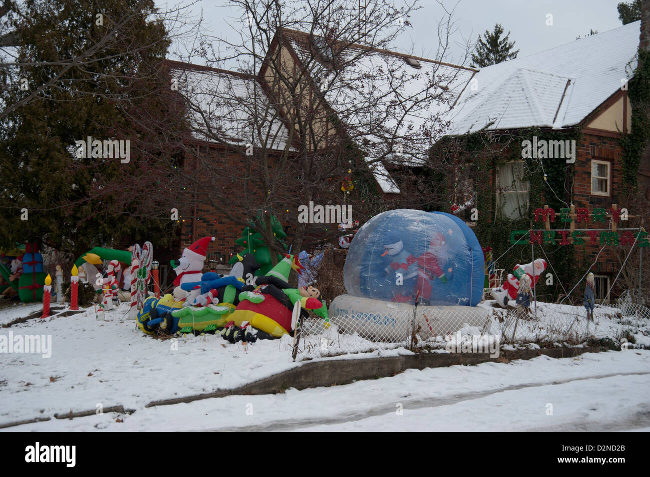 Christmas inflatable ornaments litter a front yard of a house Stock ...