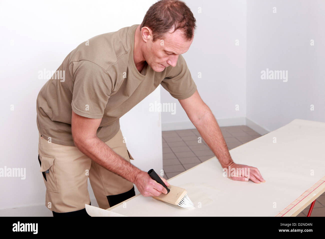 Man gluing paper Stock Photo - Alamy