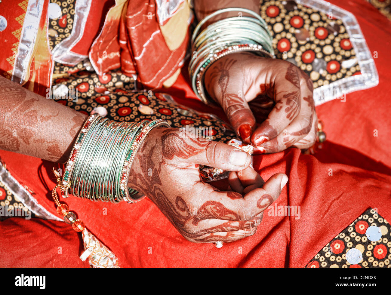 Hands of a young Indian woman adorned with traditional bangles and ...