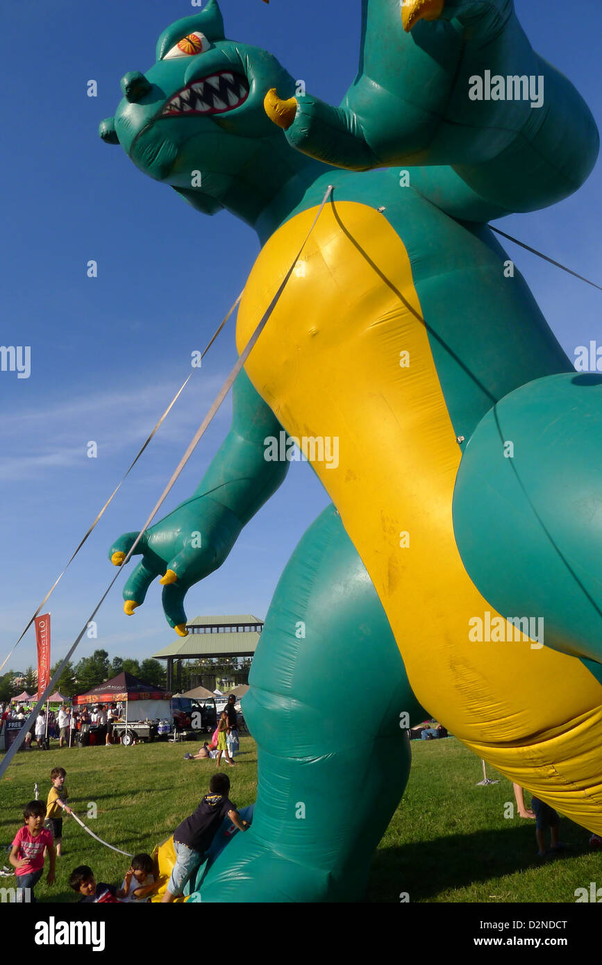 Children playing on a giant inflatable character at a children's fun ...