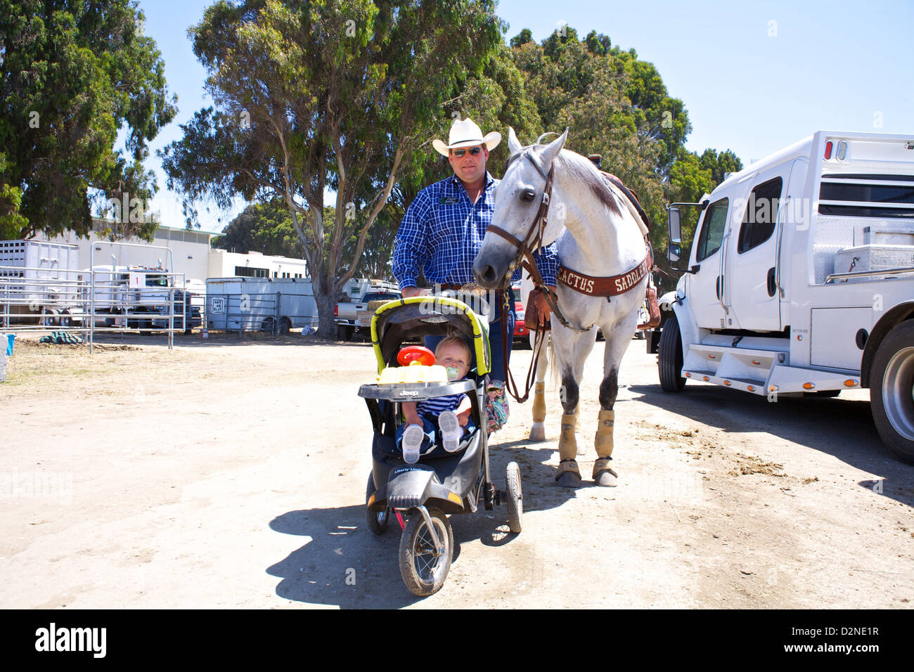 Cowboy with his horse and baby in a stroller at Salinas Rodeo ...