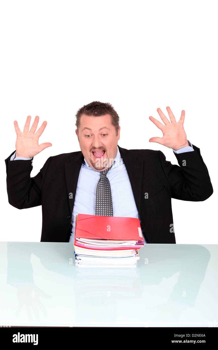 Man shocked at his pile of paperwork Stock Photo - Alamy