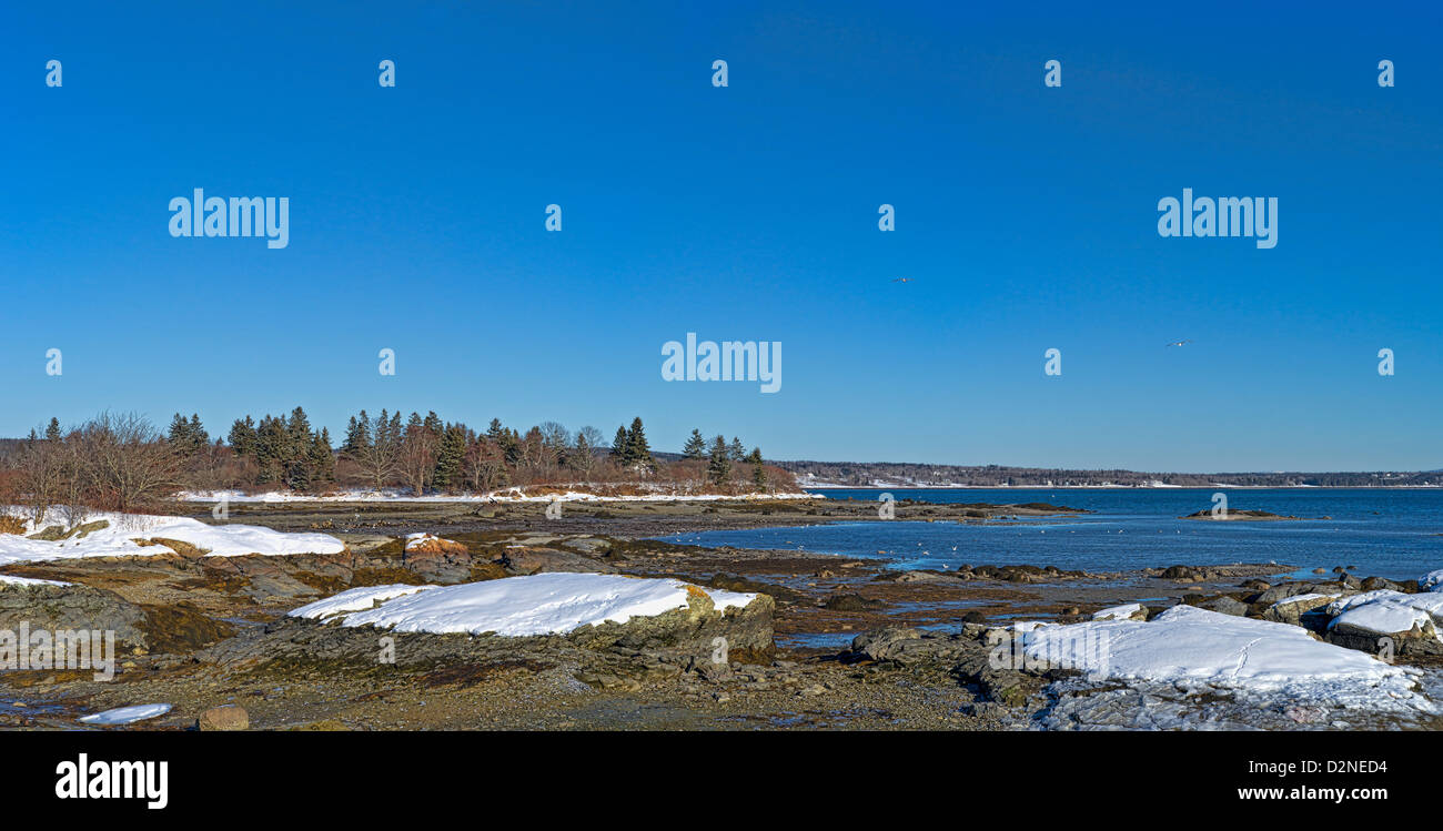 View of the ocean and rocky shoreline with snow covering at Little Deer ...