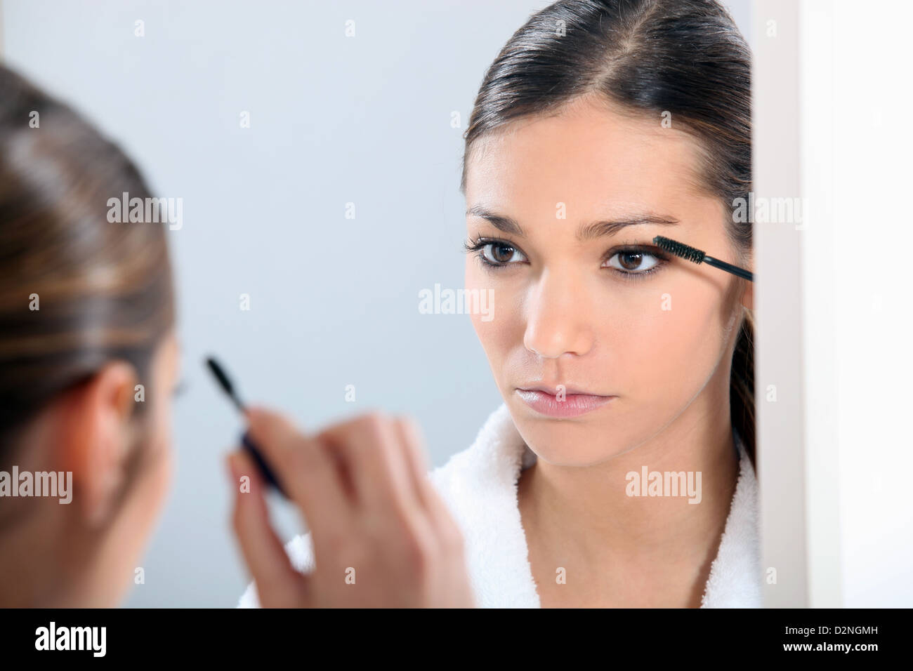 Brunette applying eye make-up Stock Photo - Alamy