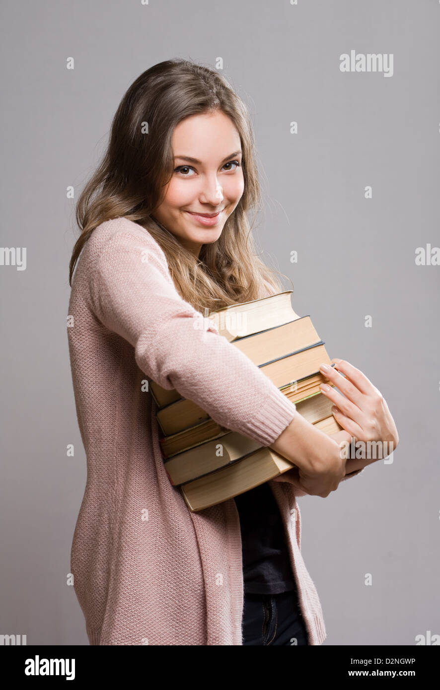 Portrait of happy student girl hugging a pile of books Stock Photo - Alamy