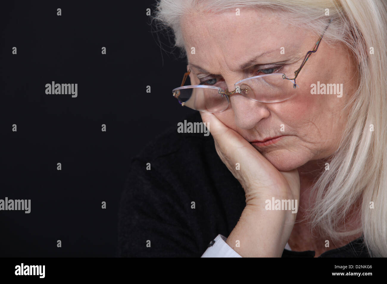 grandmother looking concerned against black background Stock Photo - Alamy