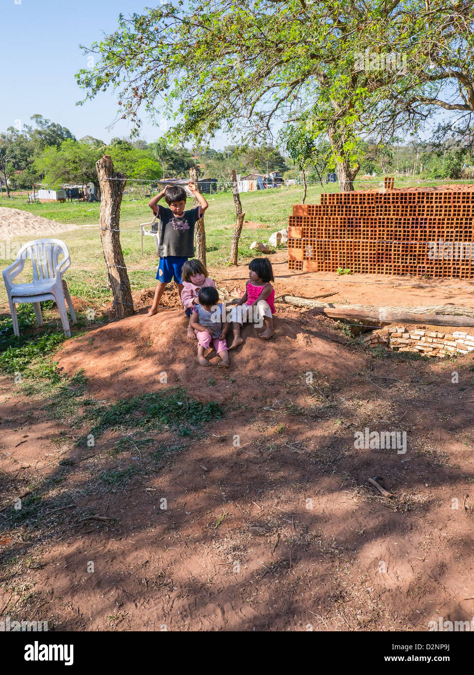 A son and daughters of the assistant mason play on a sand pile at a ...
