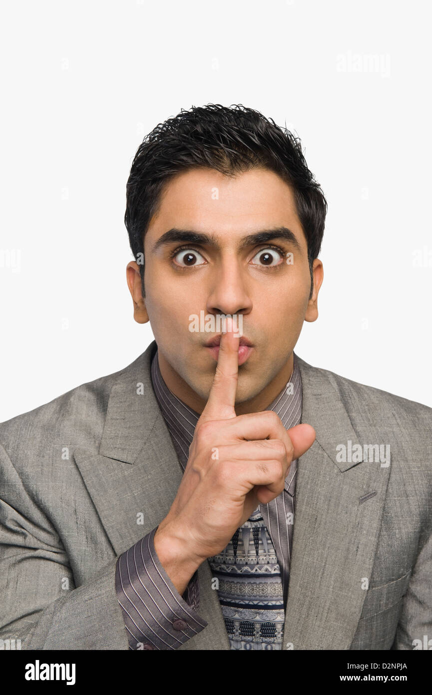 Portrait of a businessman with his finger on lips Stock Photo - Alamy