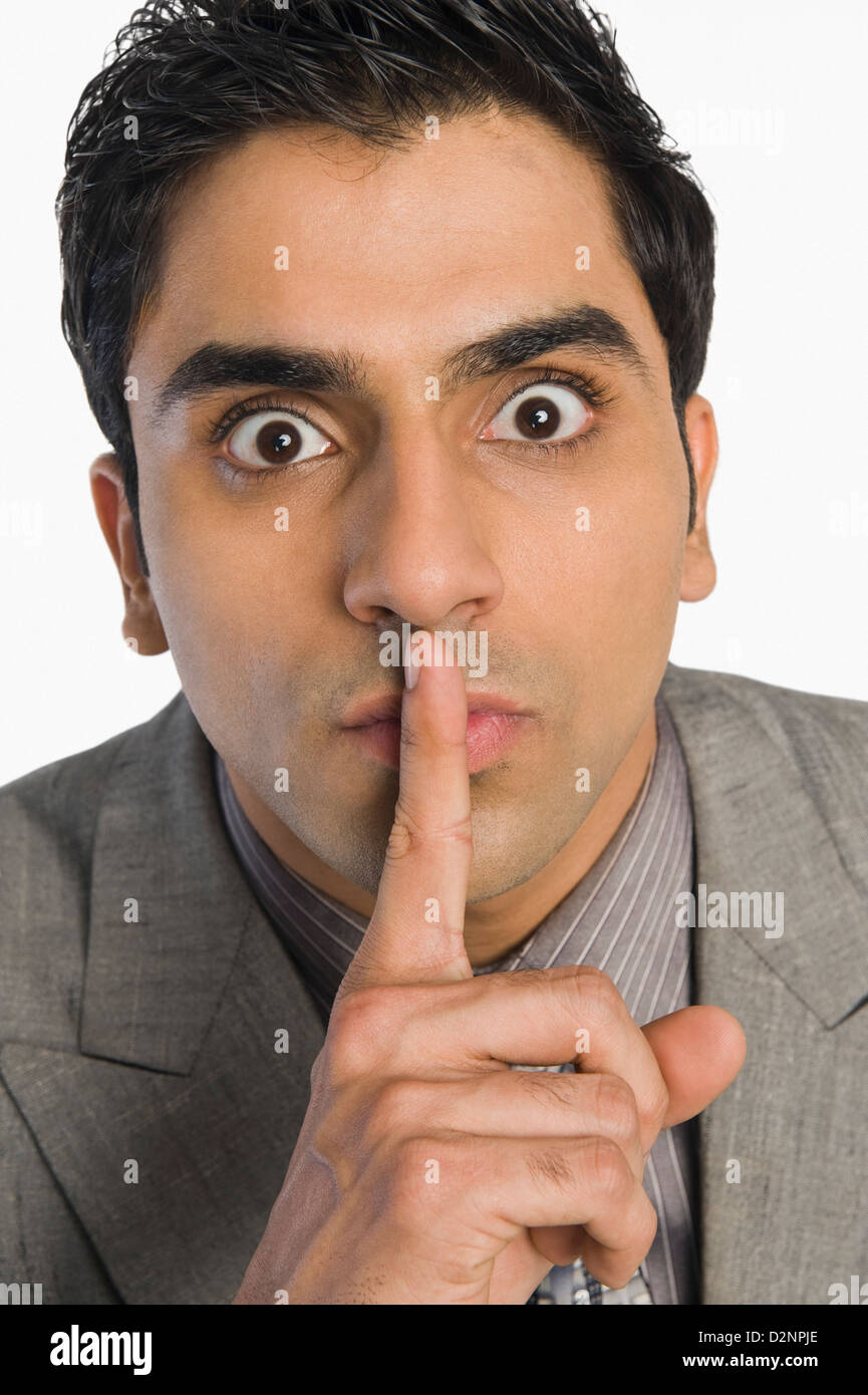 Portrait of a businessman with his finger on lips Stock Photo - Alamy