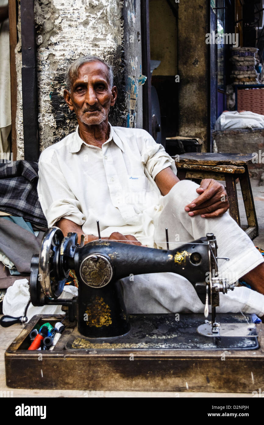 Portrait of old tailor with vintage sewing machine in Lahore, Pakistan ...