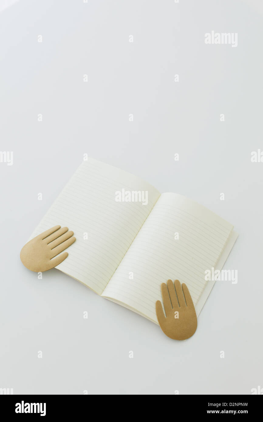 Wooden hands and notebook Stock Photo - Alamy