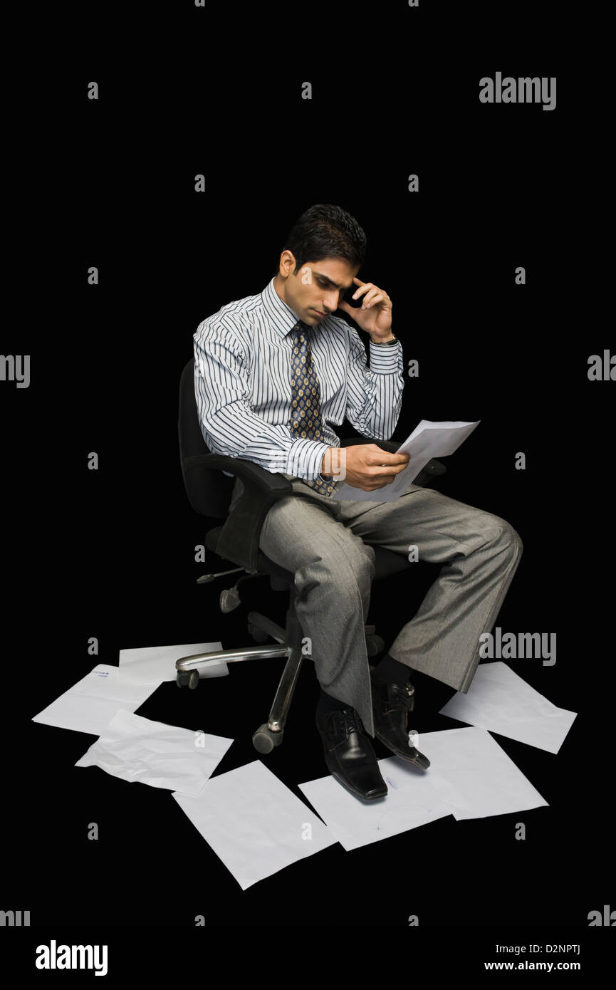 Businessman reading a document Stock Photo - Alamy