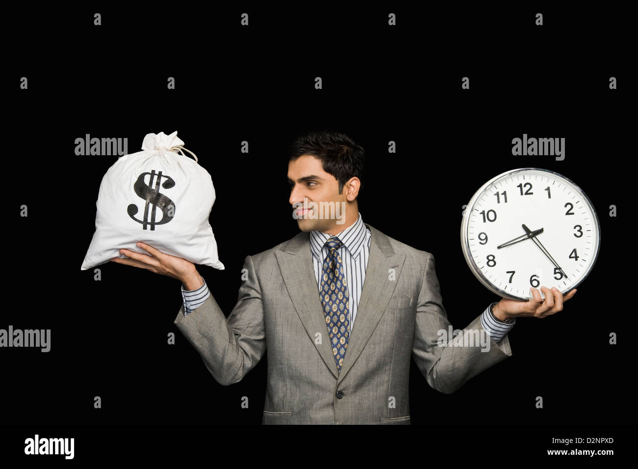 Businessman weighing time versus money Stock Photo - Alamy