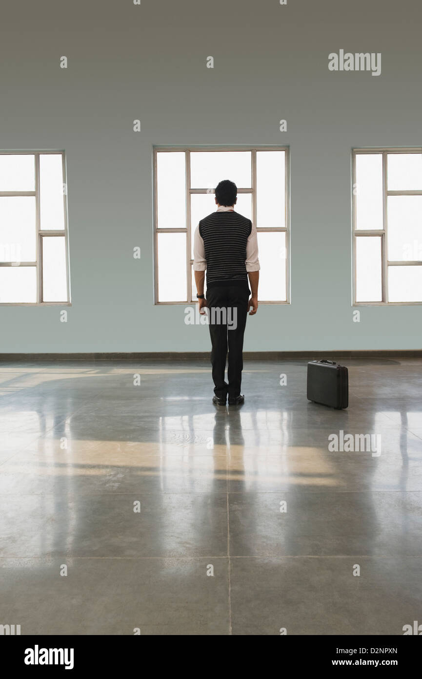 Businessman standing in an empty office Stock Photo - Alamy
