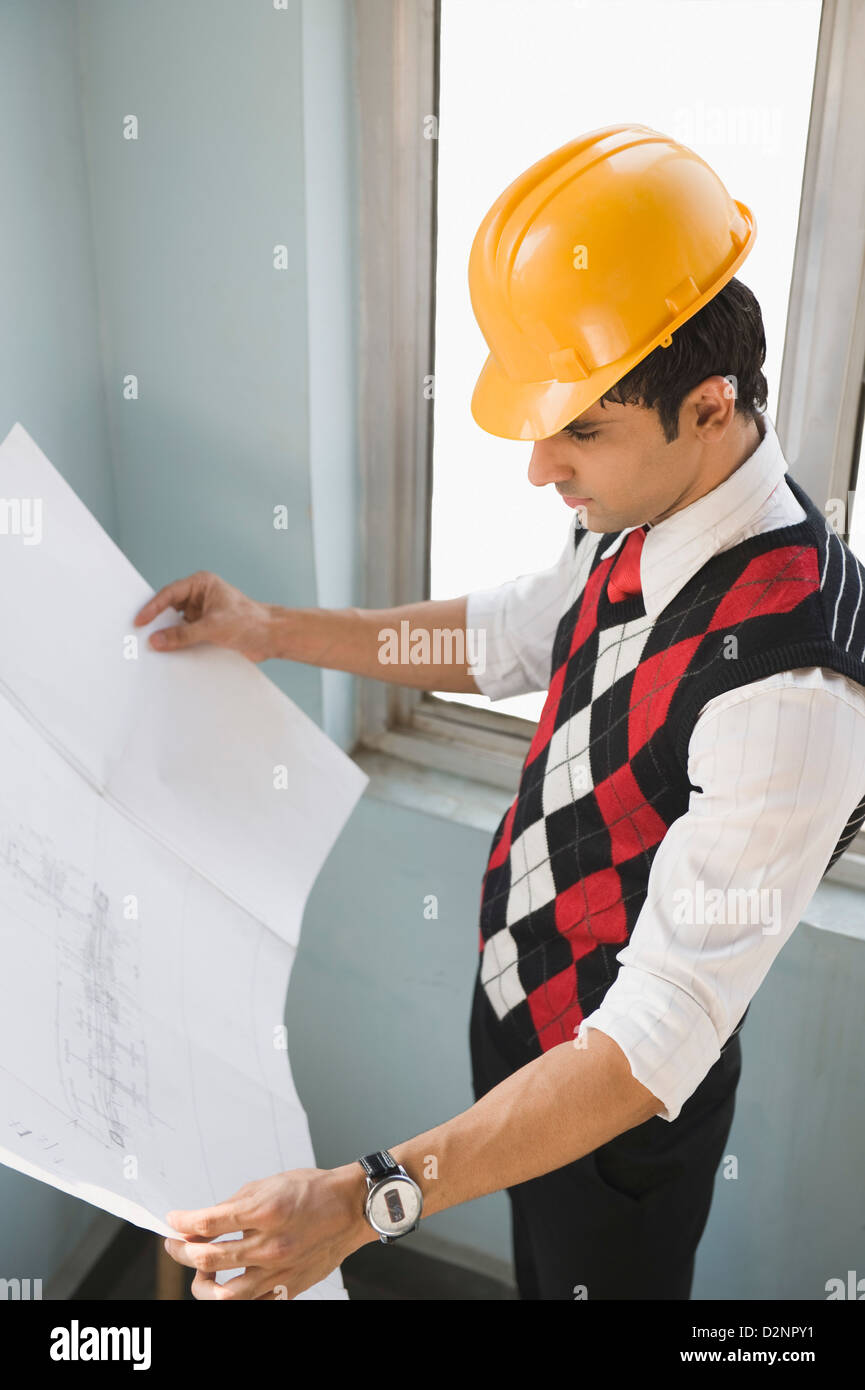Architect looking at a blueprint Stock Photo - Alamy