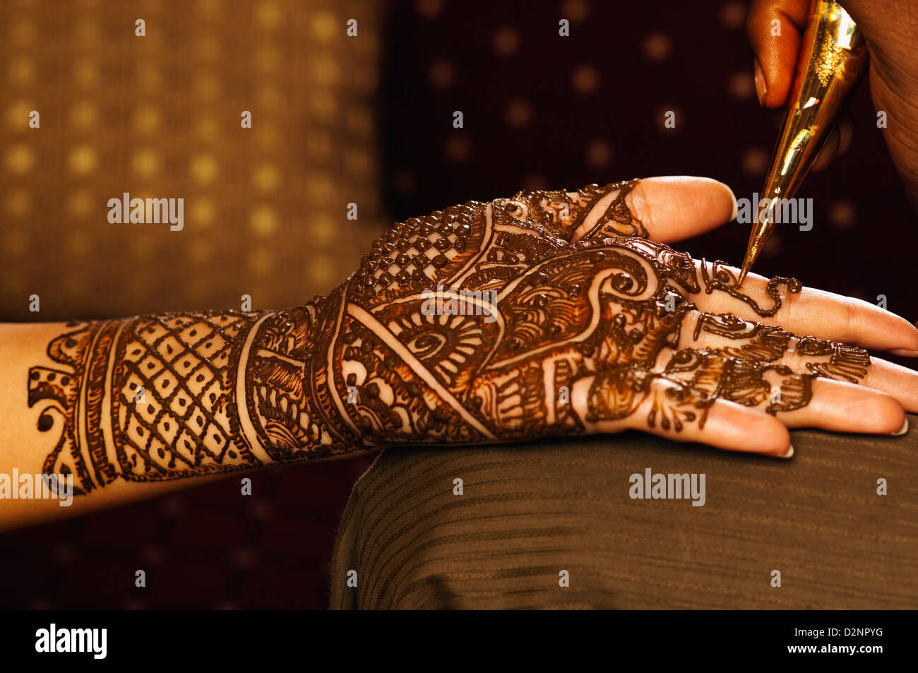 Woman's hand applying henna on bride's palm Stock Photo - Alamy