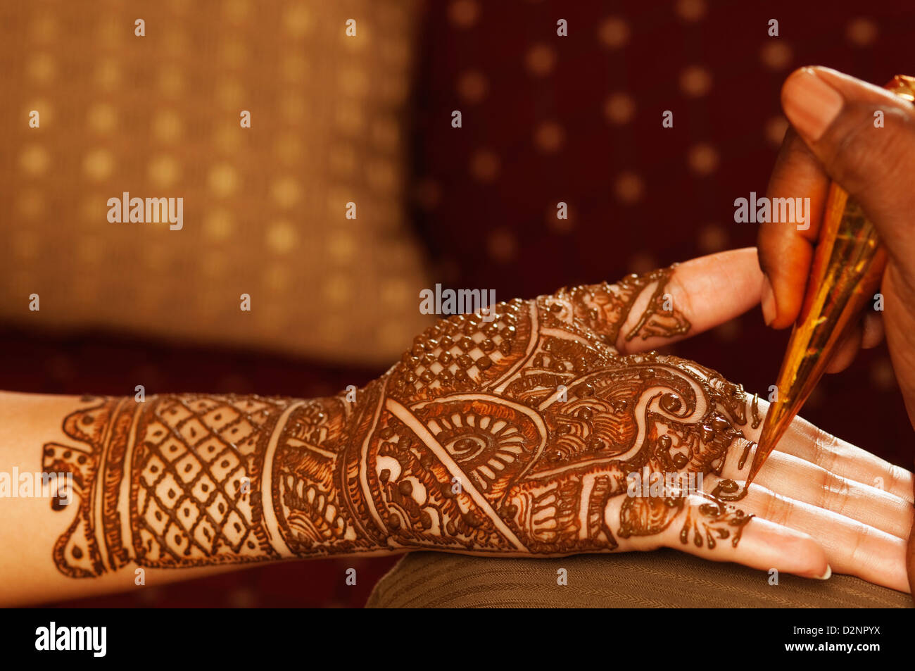 Woman's hand applying henna on bride's palm Stock Photo - Alamy