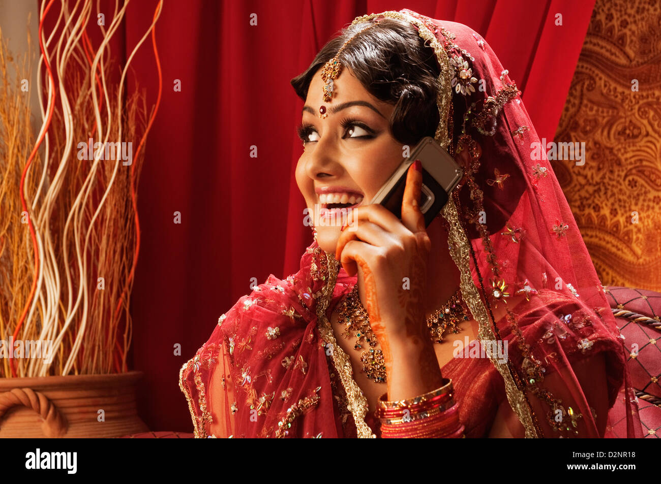 Bride in traditional wedding dress and talking on a mobile phone Stock ...