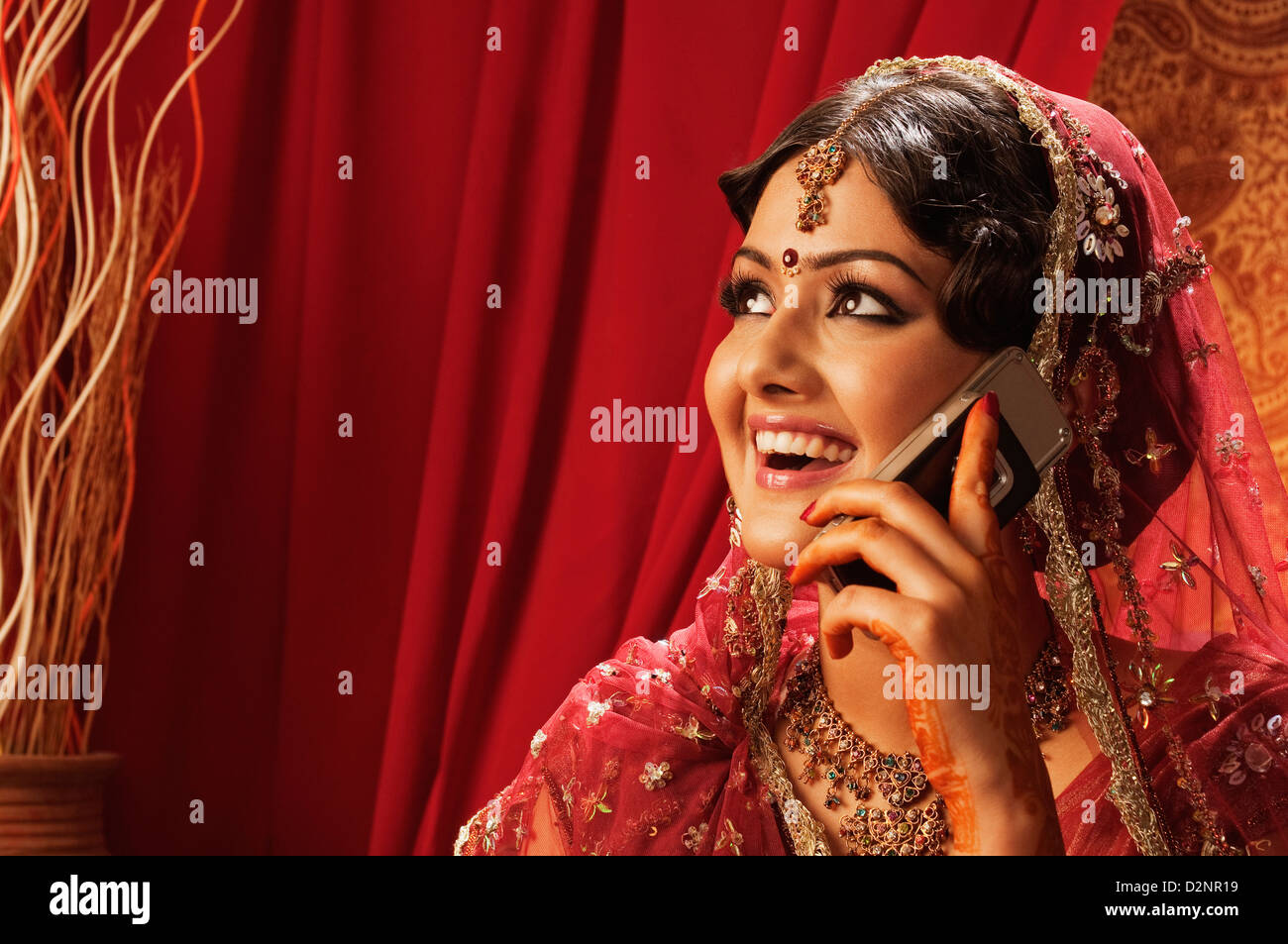 Bride in traditional wedding dress and talking on a mobile phone Stock ...