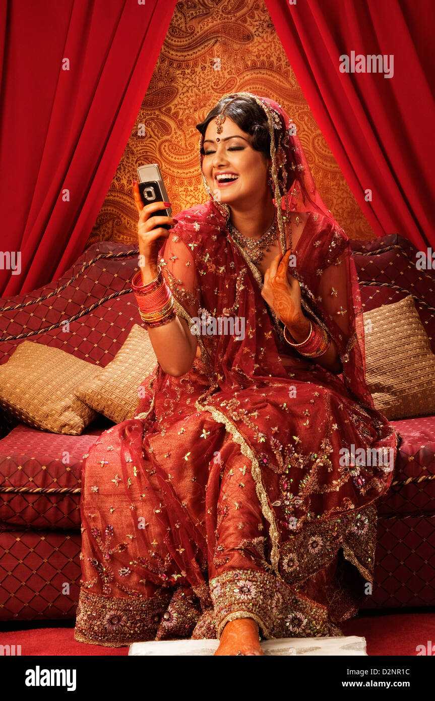 Bride in traditional wedding dress and using a mobile phone Stock Photo ...