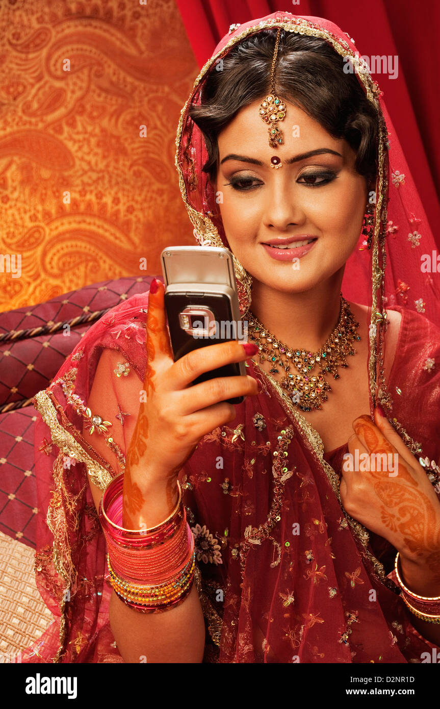 Bride in traditional wedding dress and using a mobile phone Stock Photo ...