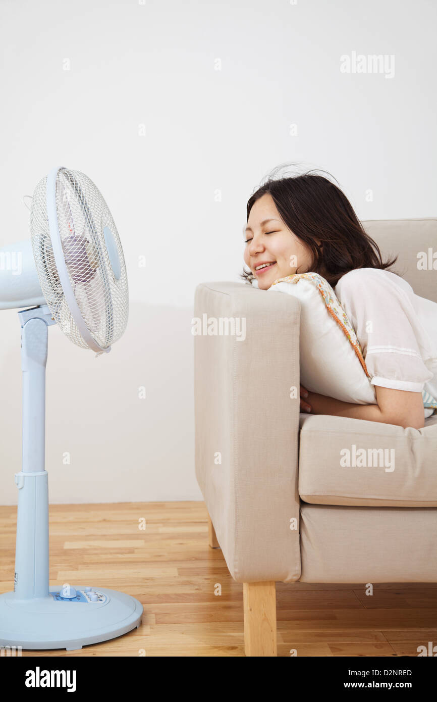 Young woman cooling off on the sofa Stock Photo - Alamy