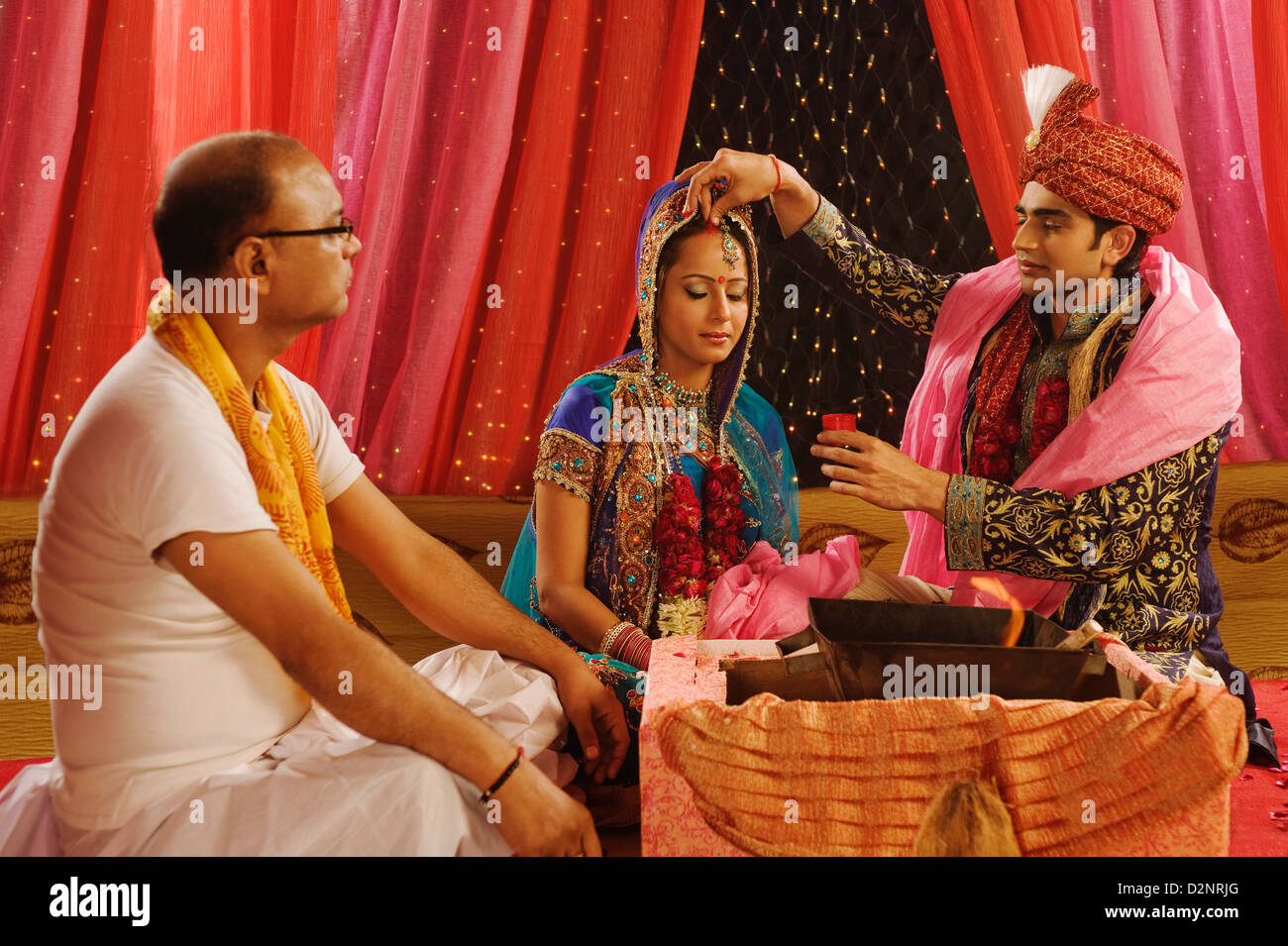Couple performing Sindoor Daan ceremony in wedding mandap Stock Photo ...