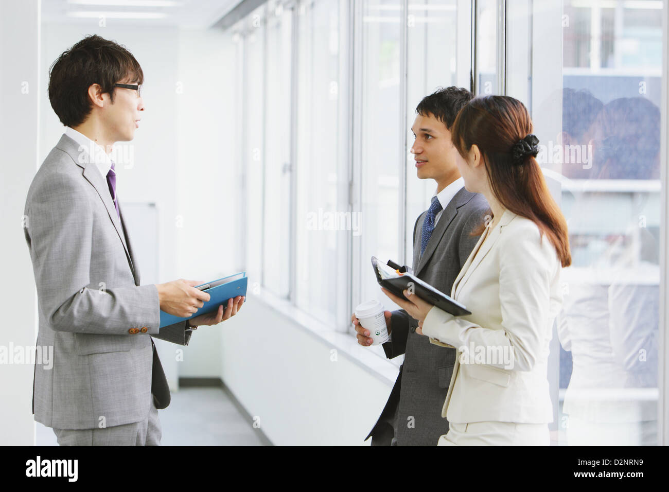 Businesspeople talking by the window Stock Photo - Alamy