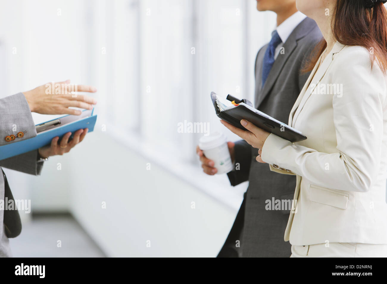 Businesspeople talking by the window Stock Photo - Alamy
