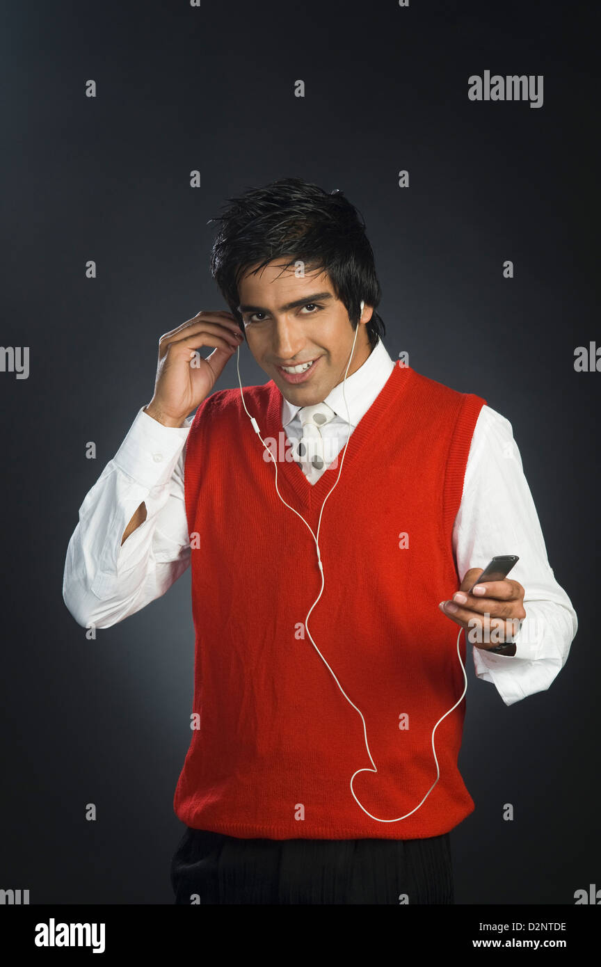 Businessman listening to an MP3 player and smiling Stock Photo - Alamy