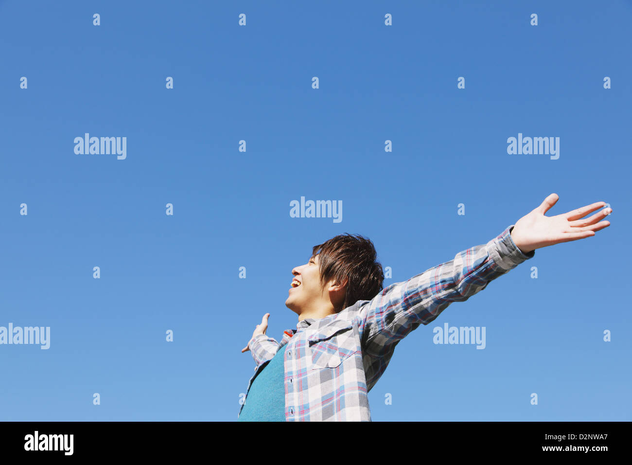 Young man spreading arms Stock Photo - Alamy