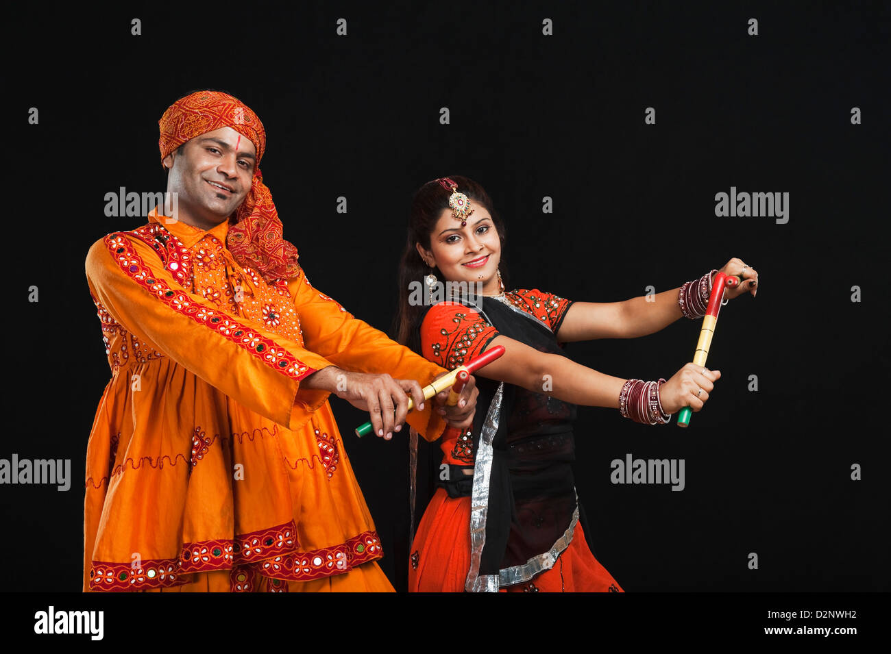 Couple performing dandiya Stock Photo - Alamy