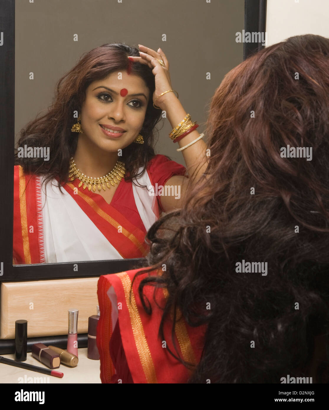 Woman applying sindoor on her head Stock Photo - Alamy