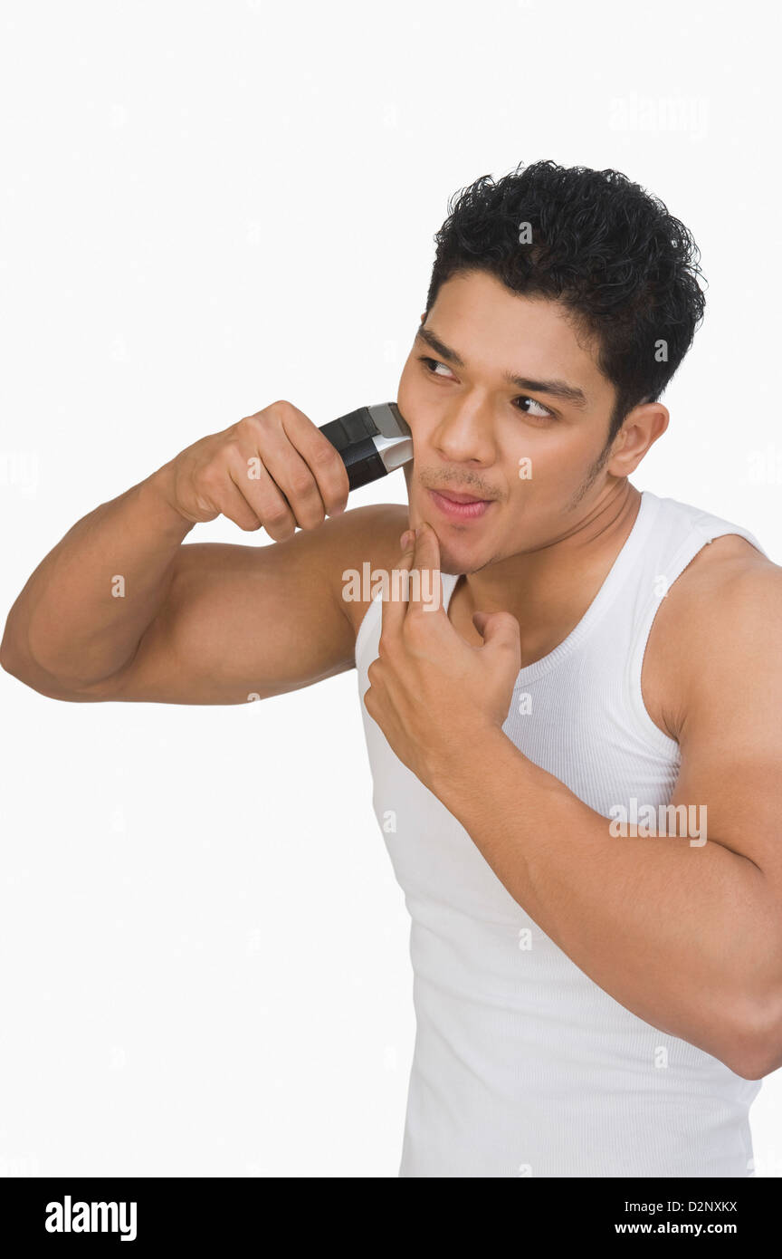 Man shaving his face with an electric razor Stock Photo - Alamy