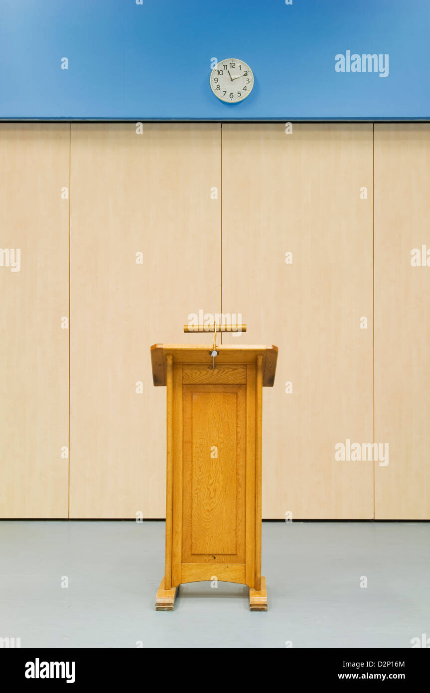 Wooden lectern and clock in the main hall of a modern secondary school ...