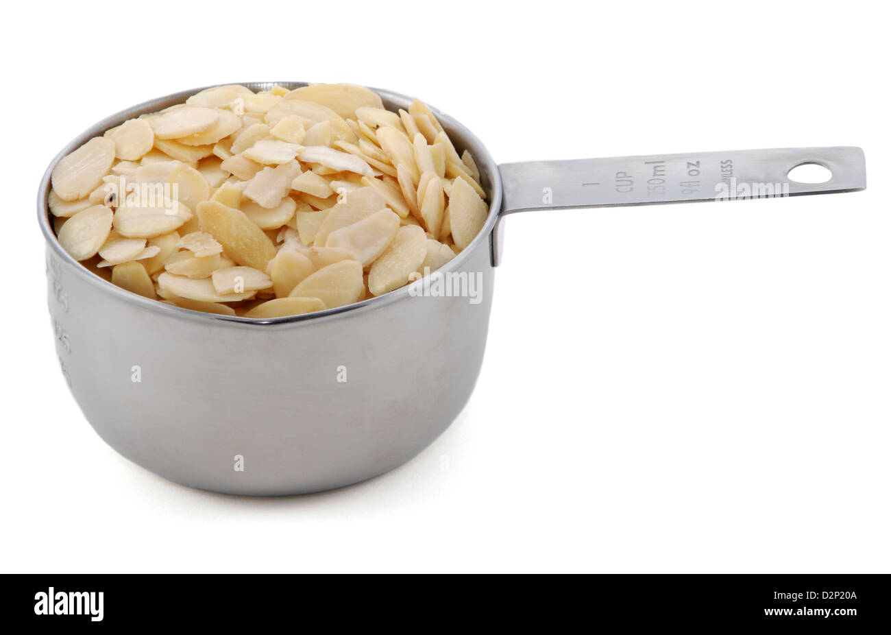 Flaked almonds presented in an American metal cup measure, isolated on ...