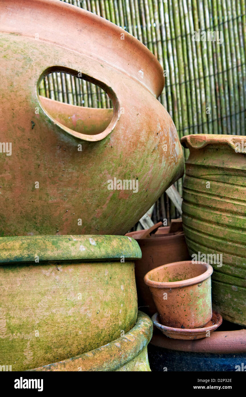 Old and used garden pots and tubs piled up which have gone mossy and ...