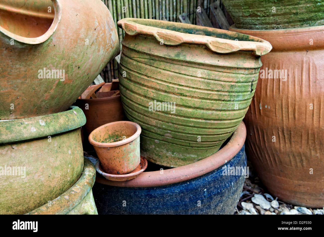 Old and used garden pots and tubs piled up which have gone mossy and ...