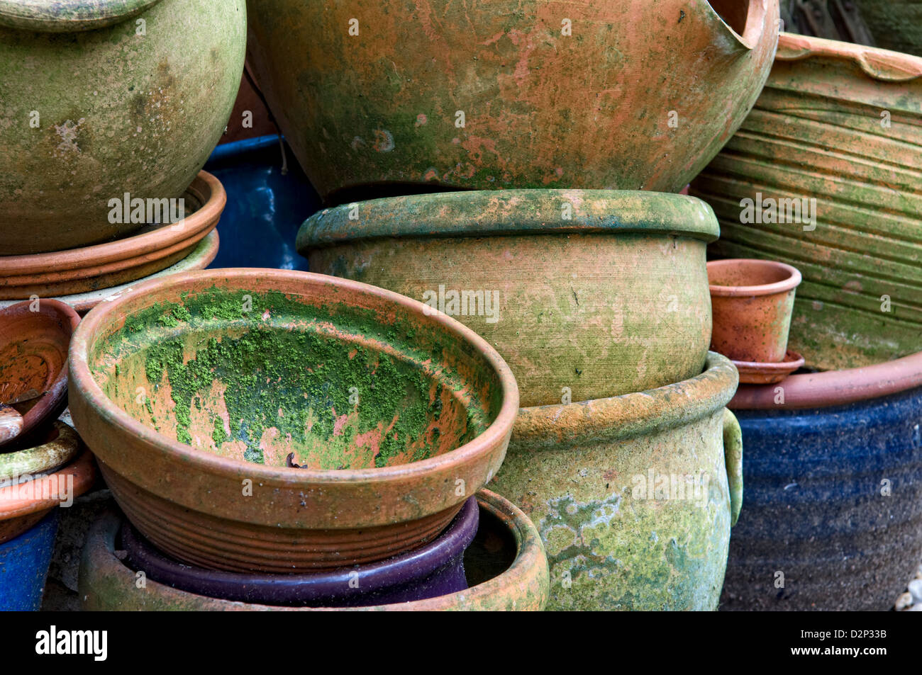 Old and used garden pots and tubs piled up which have gone mossy and ...