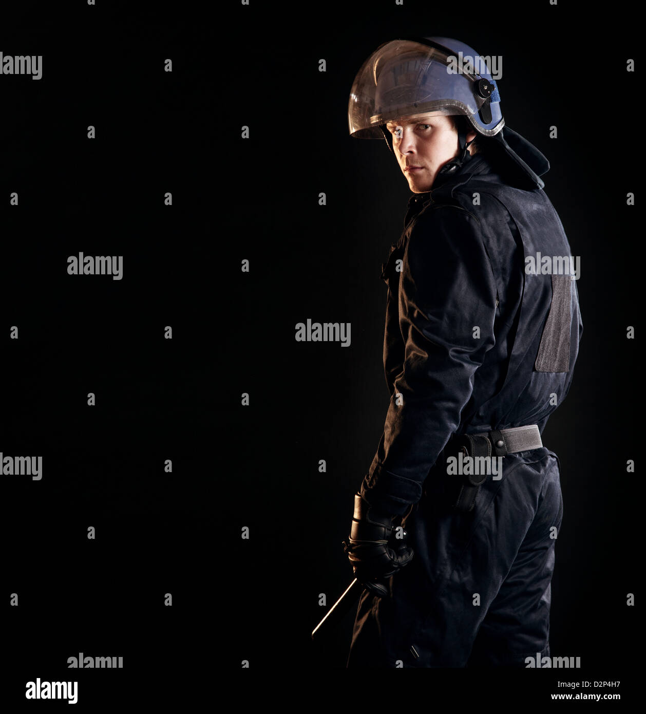 Portrait of a serious riot policeman isolated on black Stock Photo - Alamy