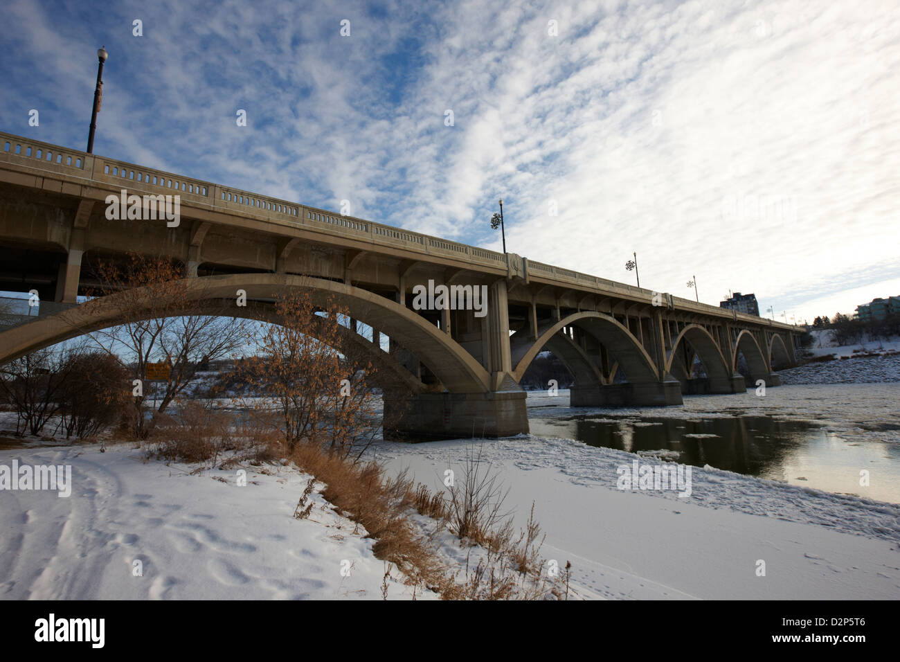 broadway bridge over the south saskatchewan river in winter flowing ...