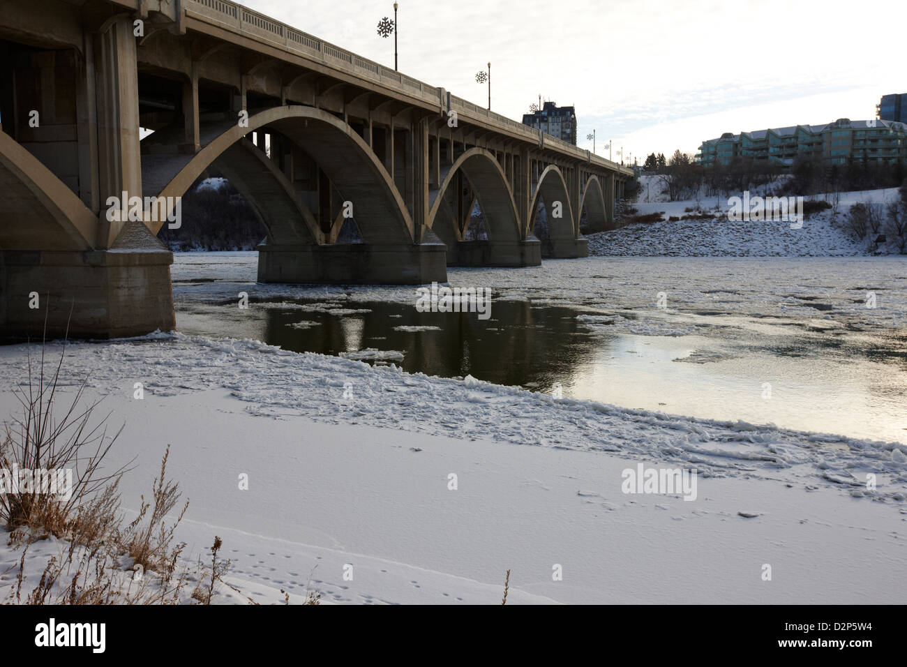 broadway bridge over the south saskatchewan river in winter flowing ...