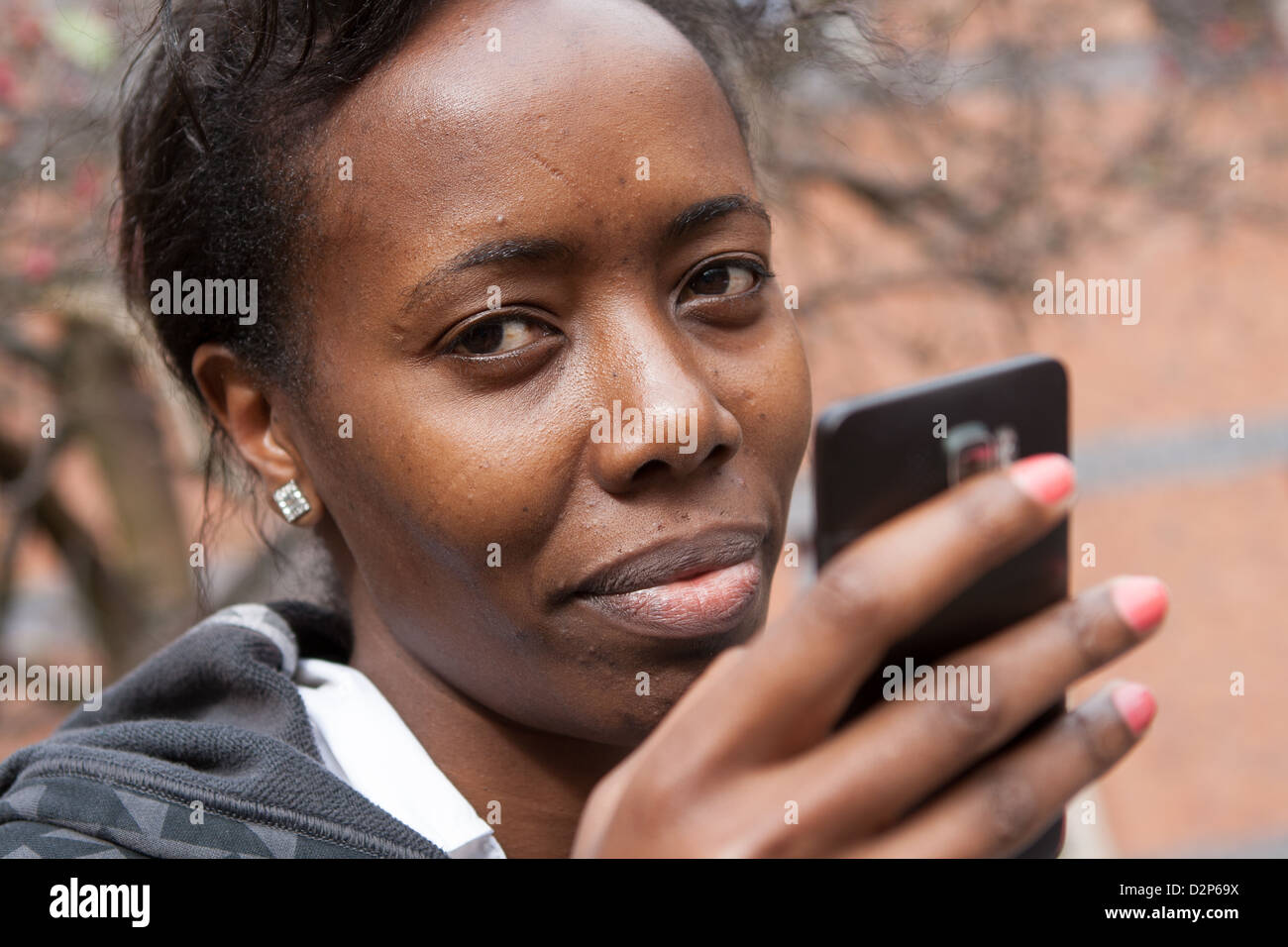 A black woman using a mobile phone Stock Photo - Alamy
