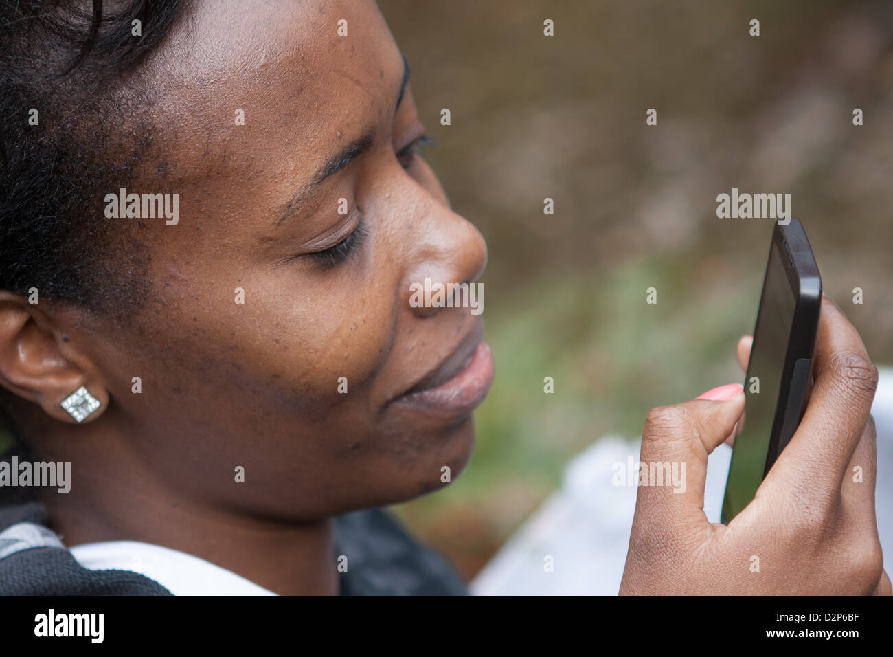A black woman using a mobile phone Stock Photo - Alamy