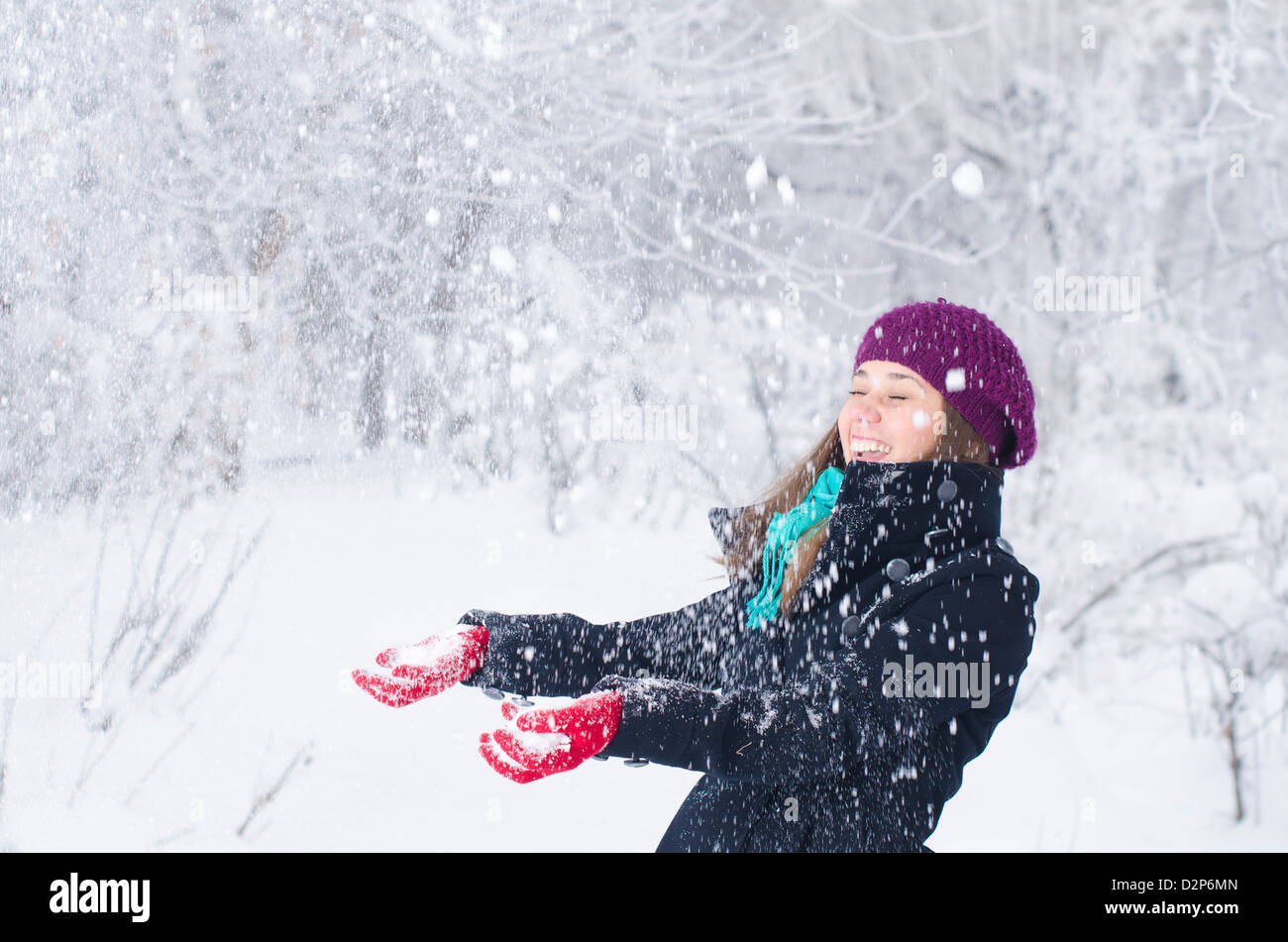 A young woman playing in the snow Stock Photo - Alamy