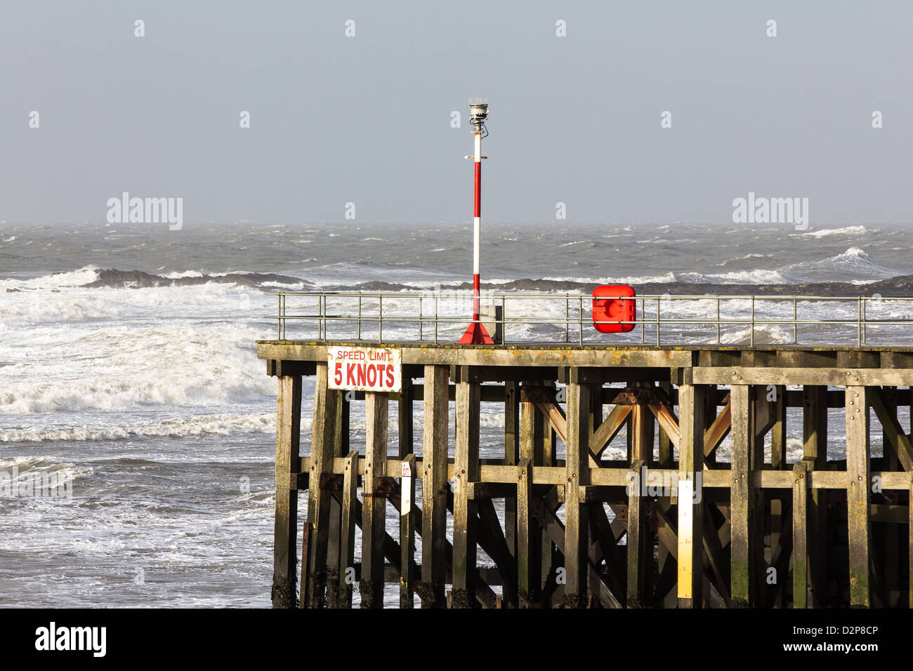 Harbour jetty at Aberystwyth, with 5 knots warning sign Stock Photo - Alamy
