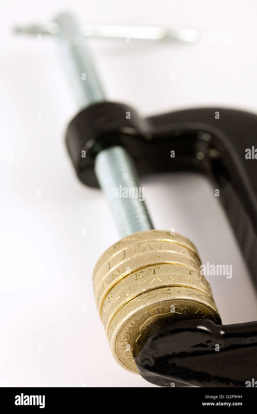 One pound coins in a clamp - the concept of british pound sterling ...