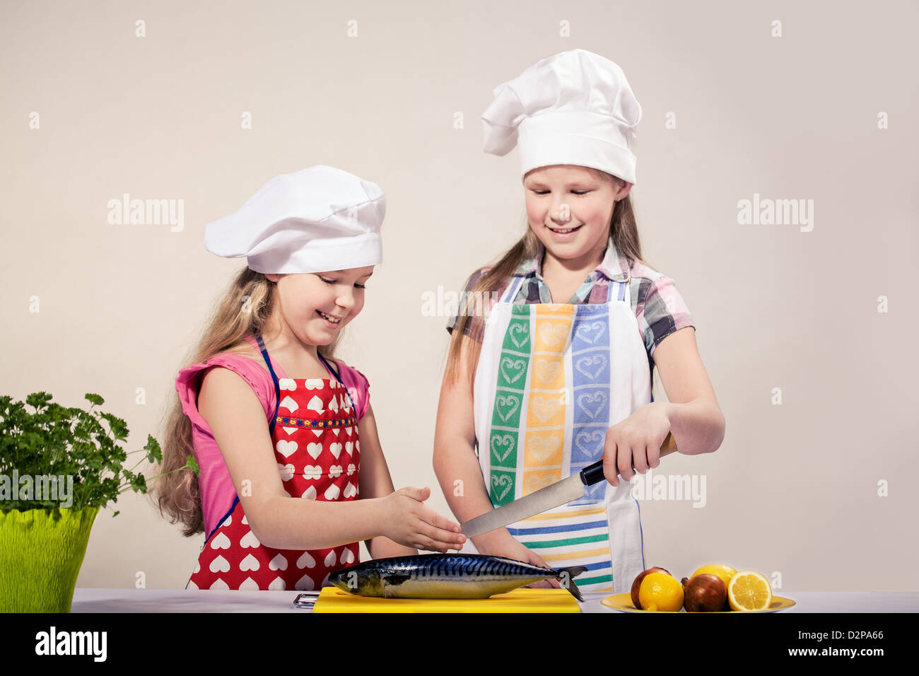 young girls cooking fish in the kitchen Stock Photo - Alamy