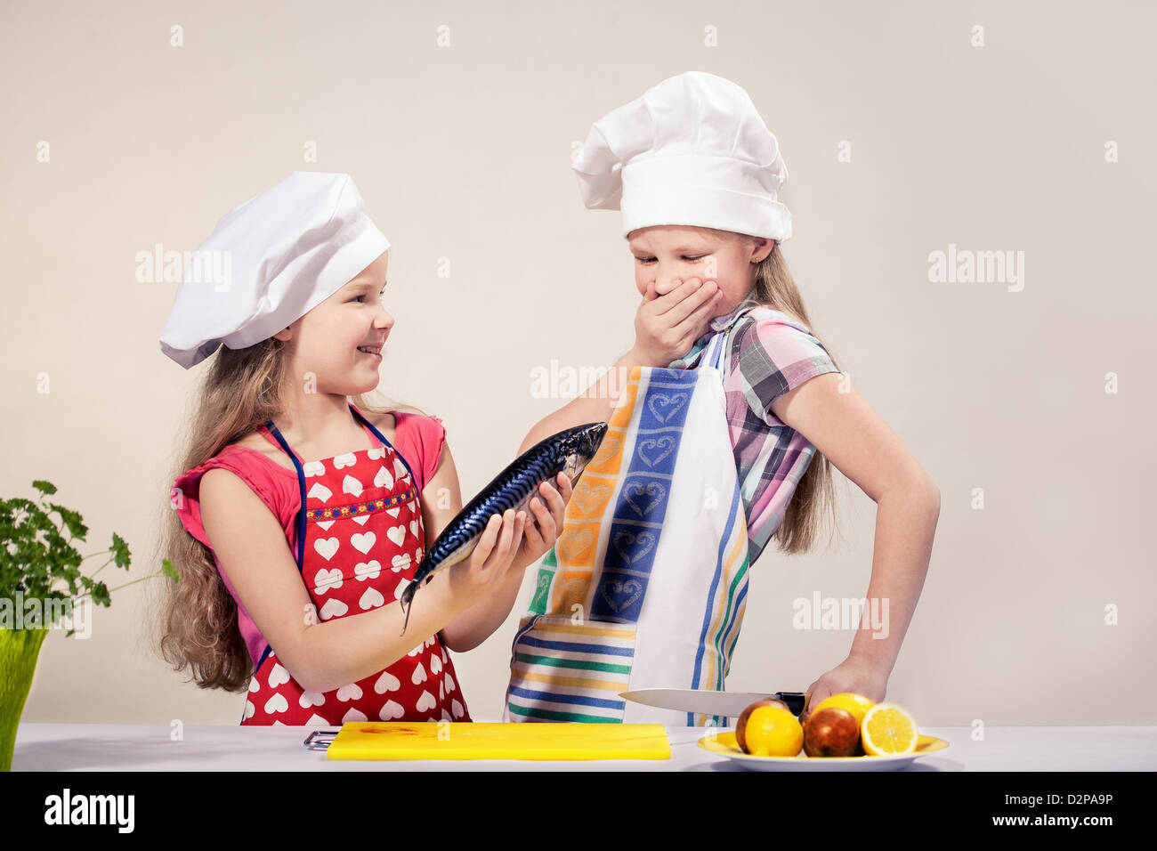 young girls cooking fish in the kitchen Stock Photo - Alamy